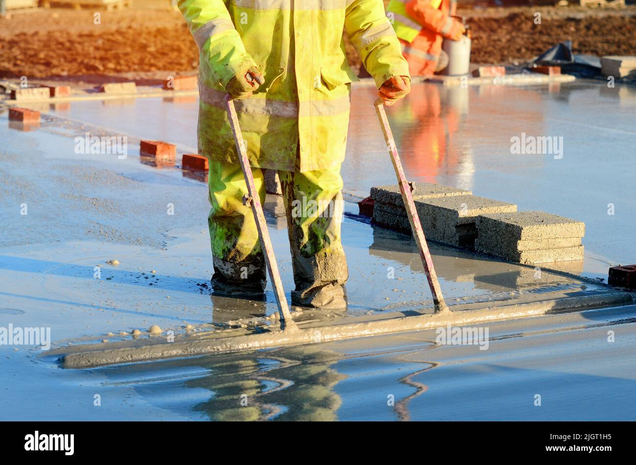 Builder pouring ground floor slab of a new house with wet ready-mix ...