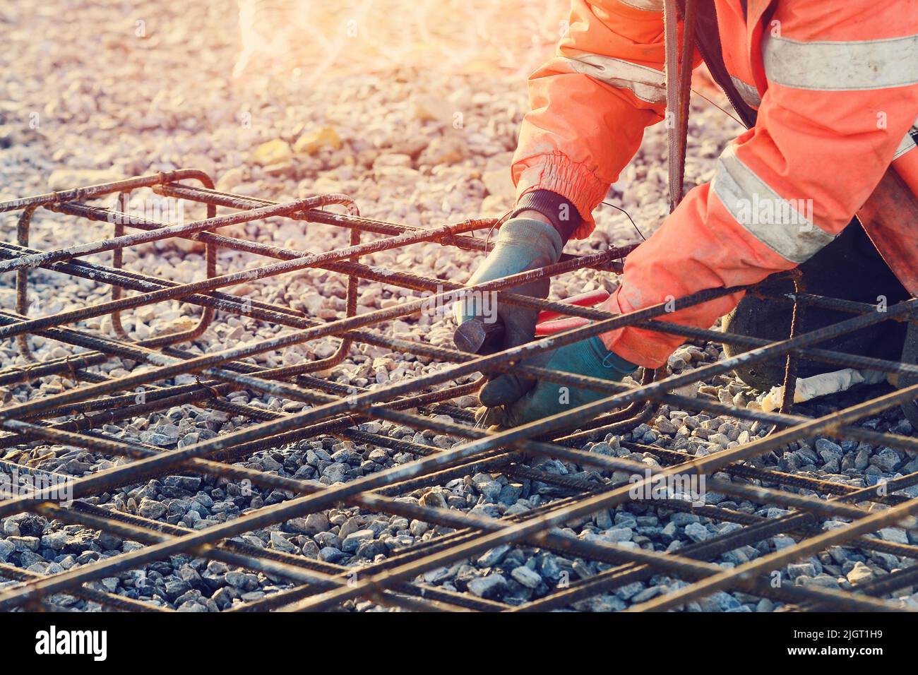 Builder's hands fixing steel reinforcement bars at construction site ...