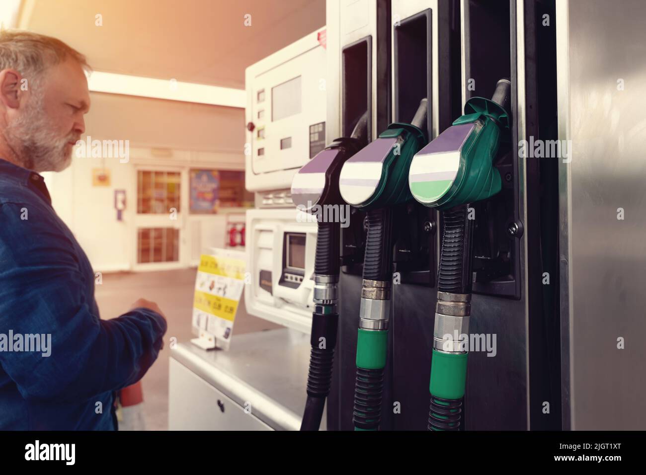 A man at gas station paying for fuel before filling tank of his car ...