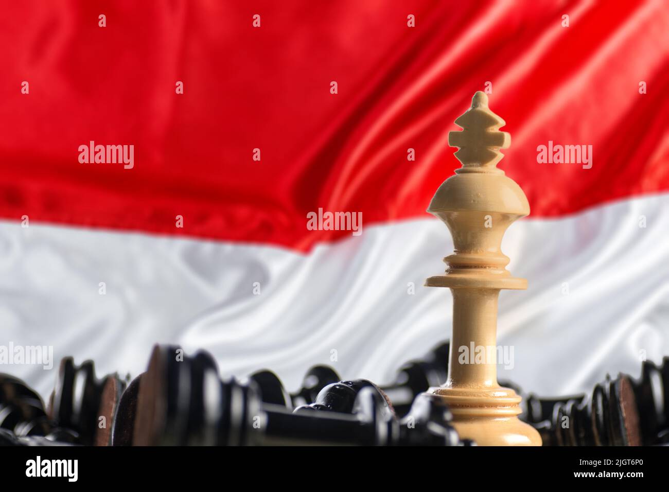 King chess piece standing above a defeated chess piece with a red and ...