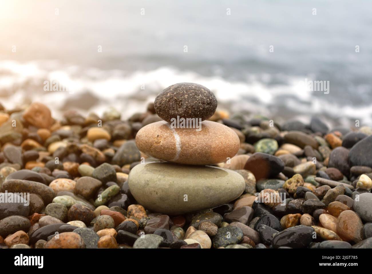 Three pebbles on each other at a beach Stock Photo - Alamy