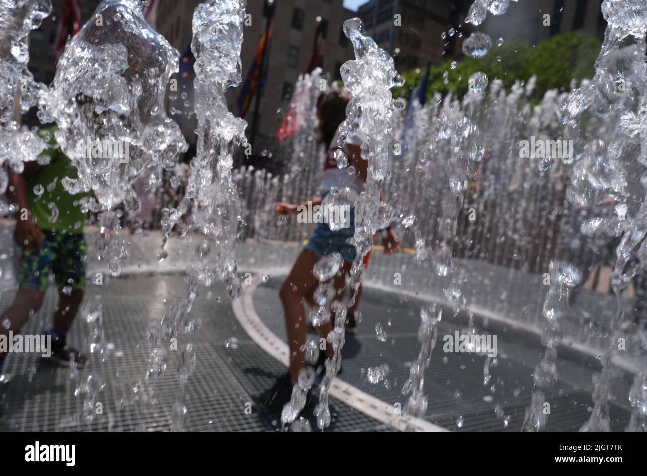 New York, New York, USA. 12th July, 2022. People run through water fountain art installation ...