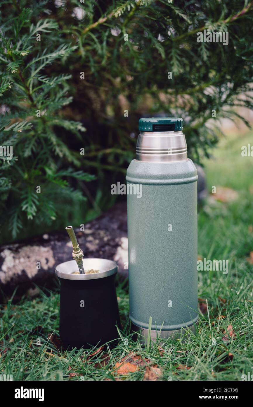 Mate and a thermo full of hot water ready to drink on a natural space ...