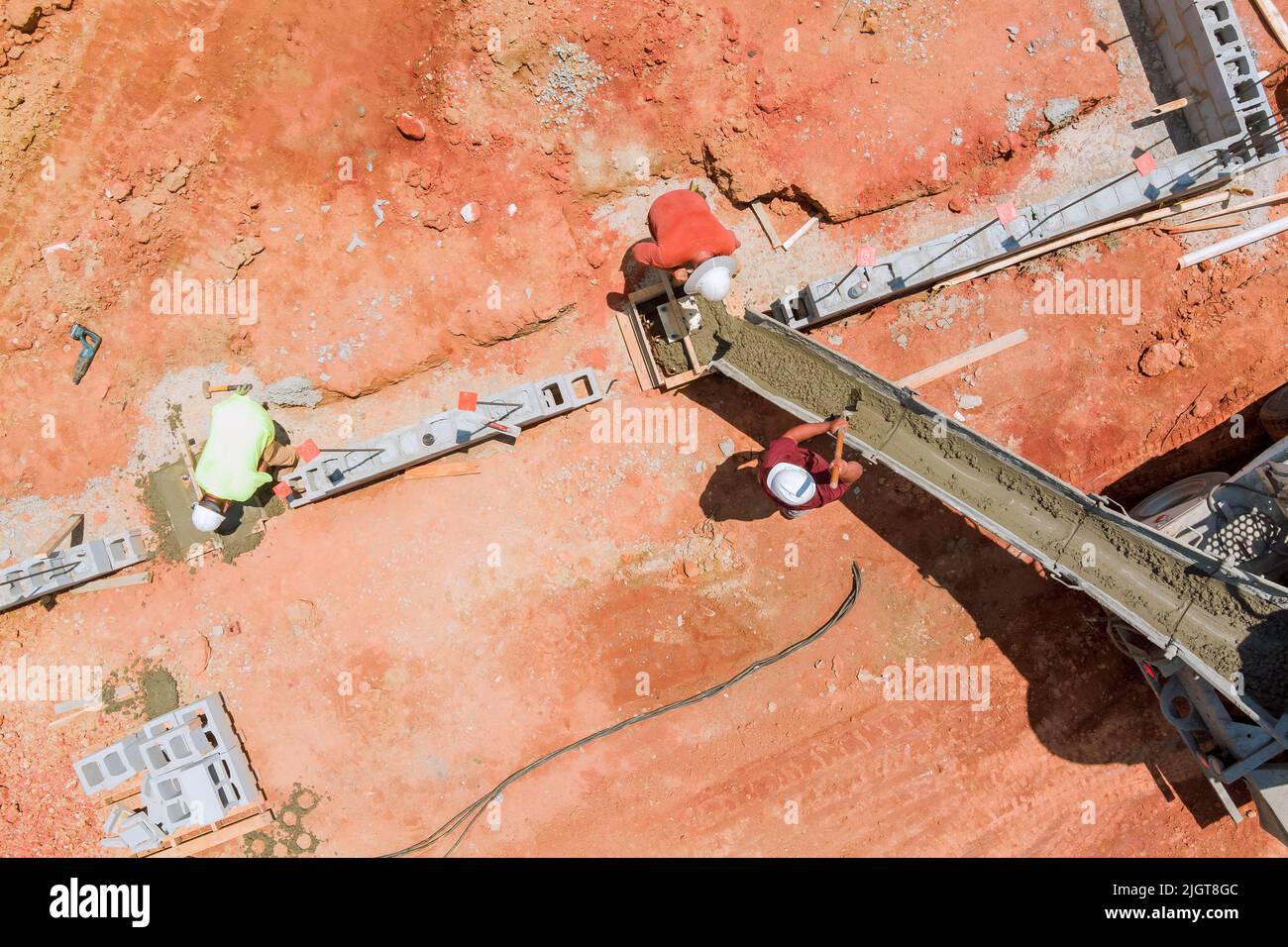 Construction workers pouring concrete columns at a building site Stock ...