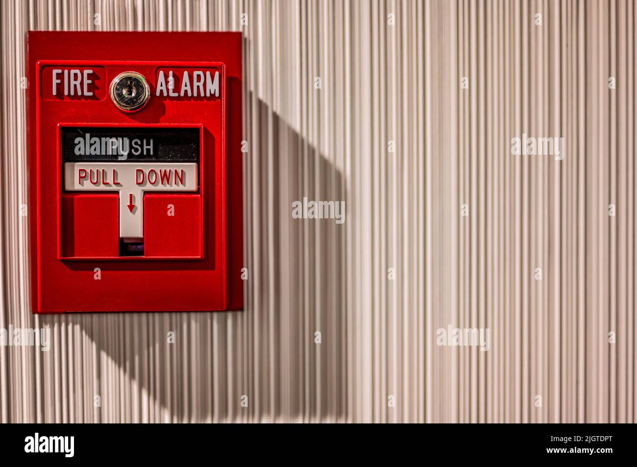 Selective focus on a wall mounted fire alarm switch in a empty hallway ...