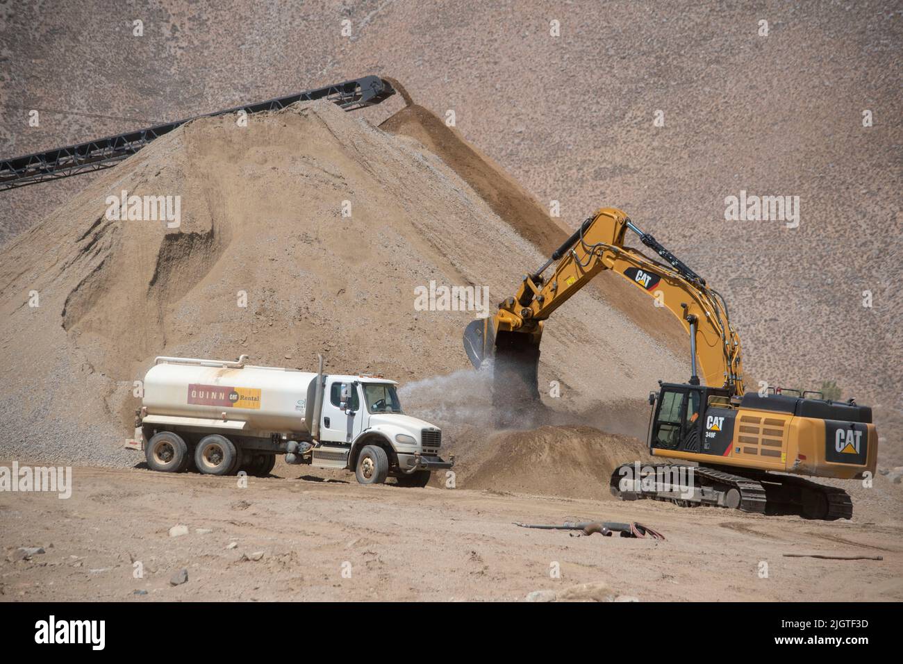 Heavy machinery works to break down rock for a highway project near ...