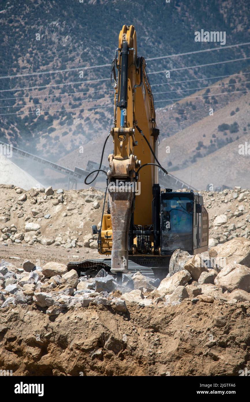 Heavy machinery works to break down rock for a highway project near ...