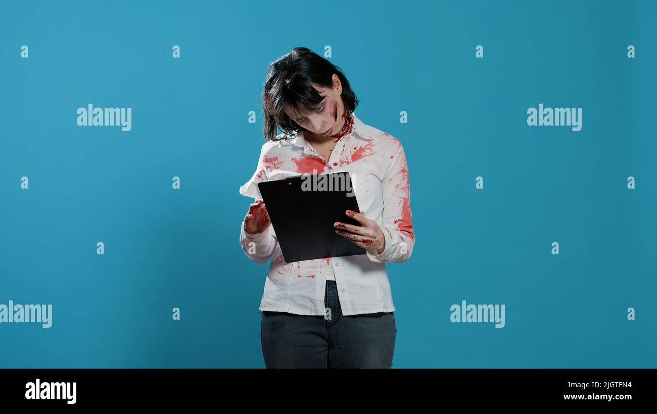 Bizarre looking person with documentation clipboard standing on blue background. Scary dangeorus ...