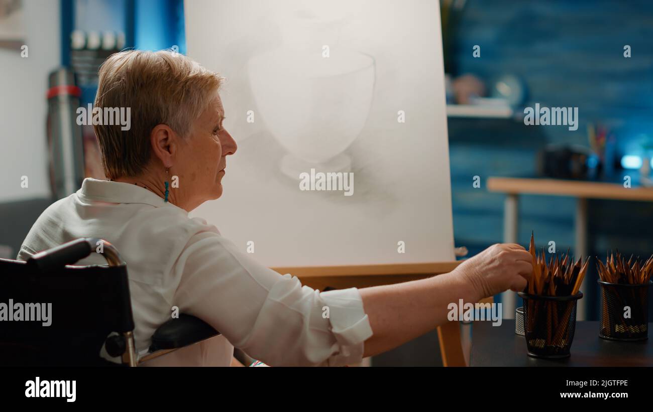 Retired person with health condition using pencils to draw vase design ...