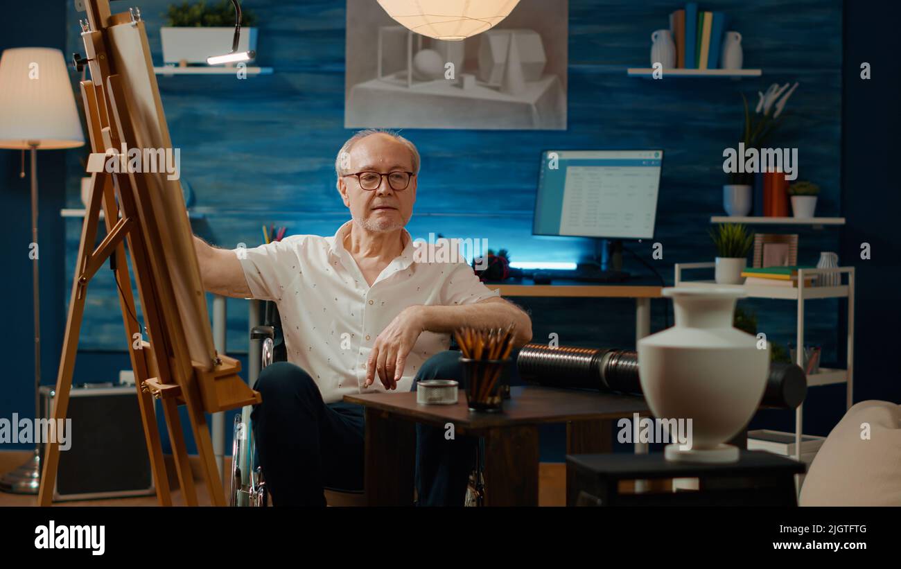 Retired man with chronic disability drawing masterpiece on canvas ...