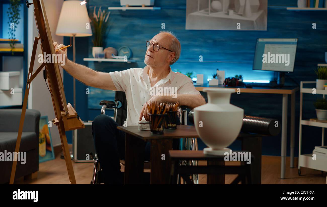 Senior man living with physical disability and drawing authentic vase ...