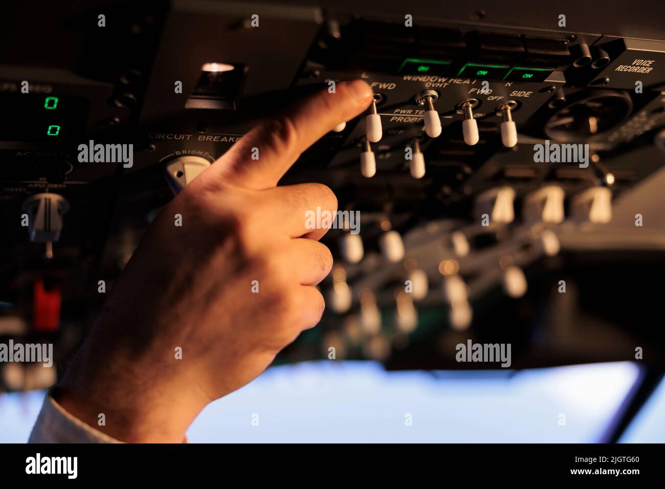 Aviation pilot using control panel in cockpit to fly airborne aircraft ...