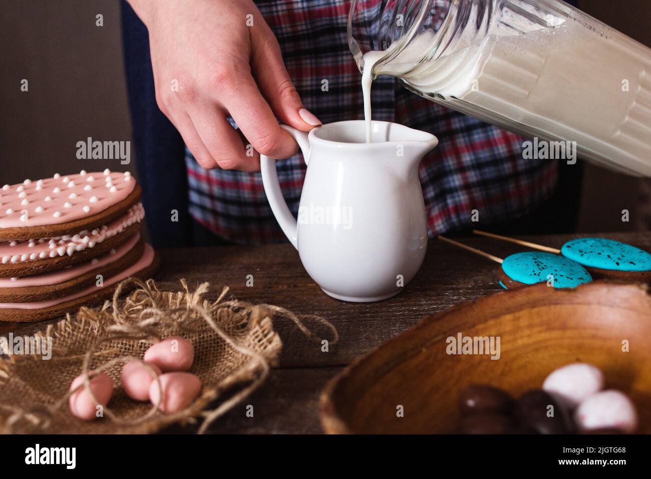 Woman pouring milk to small jar closeup Stock Photo - Alamy