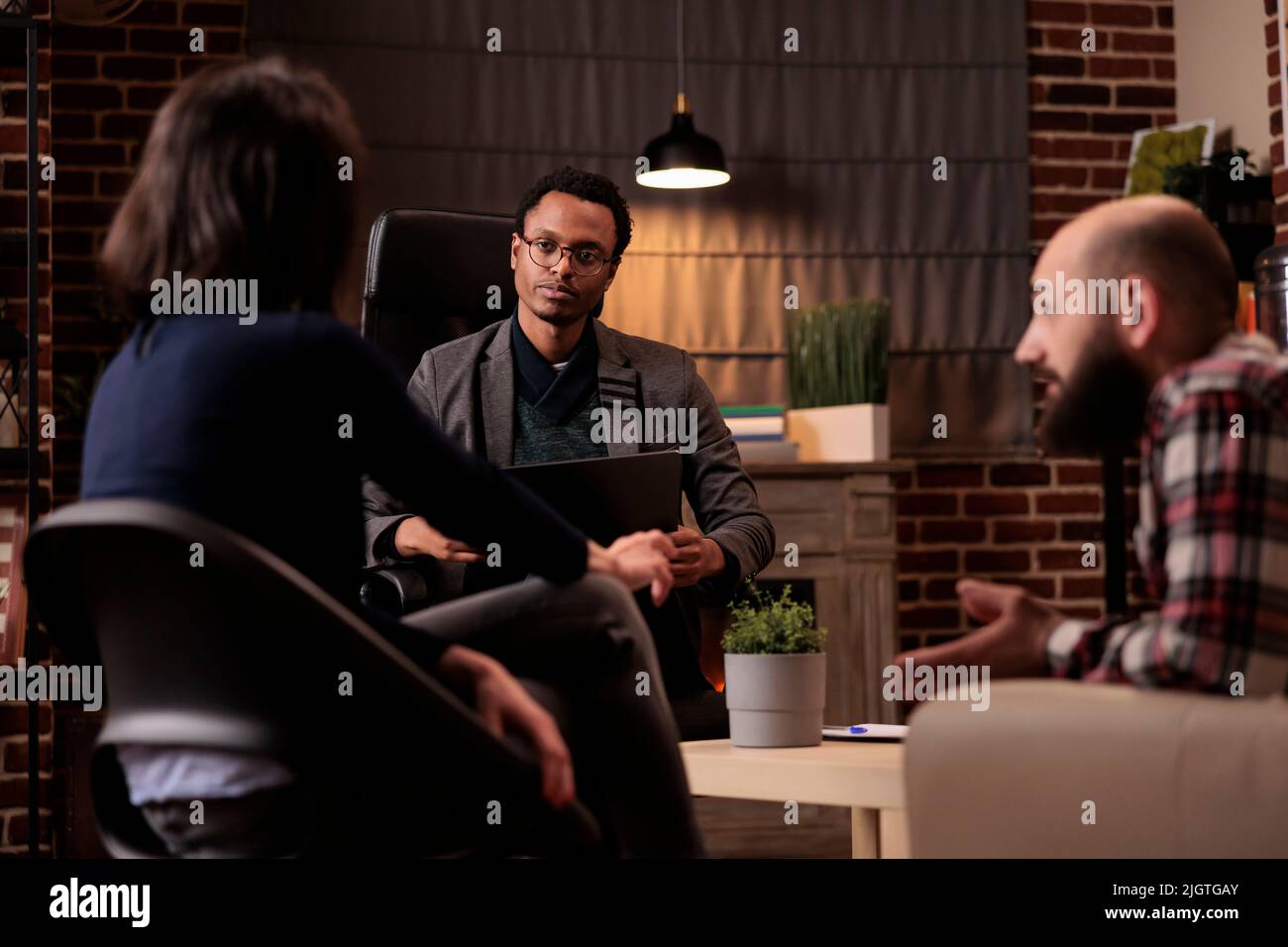 Married couple attending therapy session with counselor, talking about ...