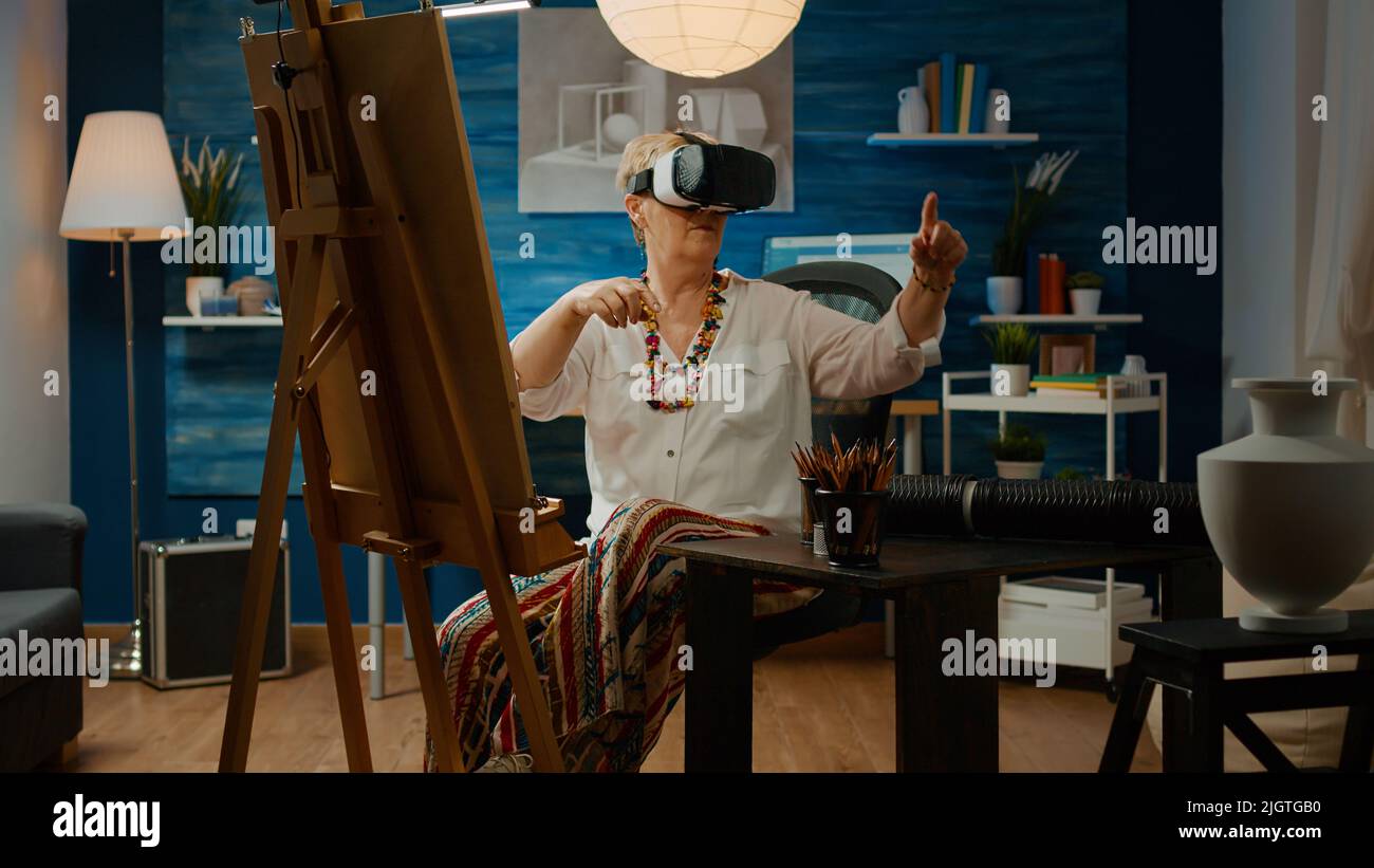 Senior artist using vr glasses with augmented reality to draw vase and ...