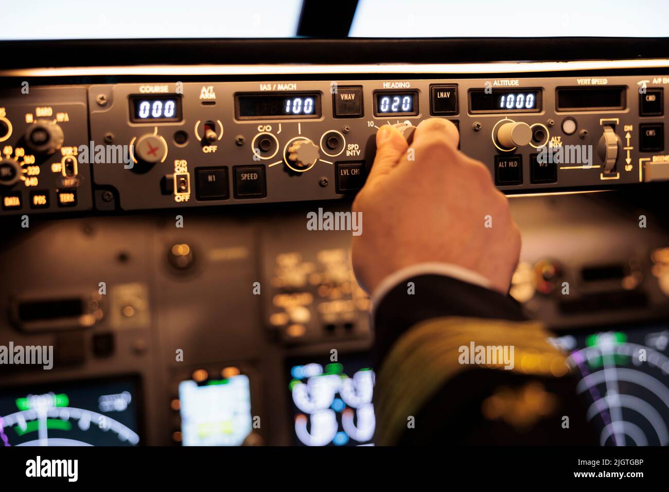 Male pilot pushing buttons to fix altitude level on control panel ...