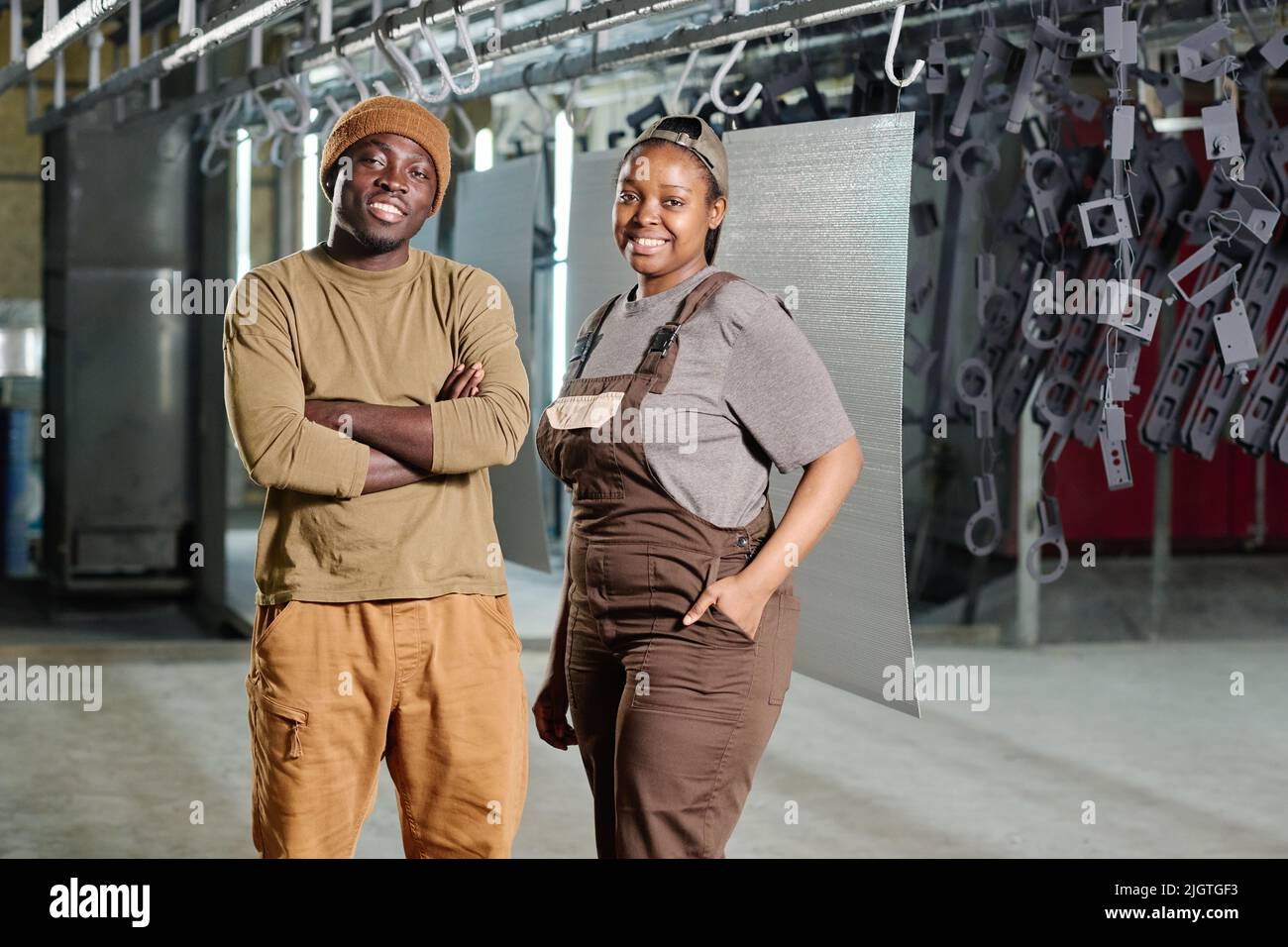 Portrait of African colleagues in workwear smiling at camera standing ...