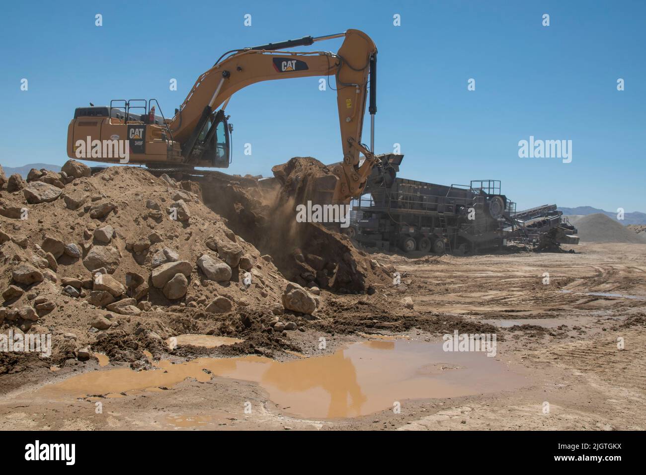 Heavy machinery works to break down rock for a highway project near ...