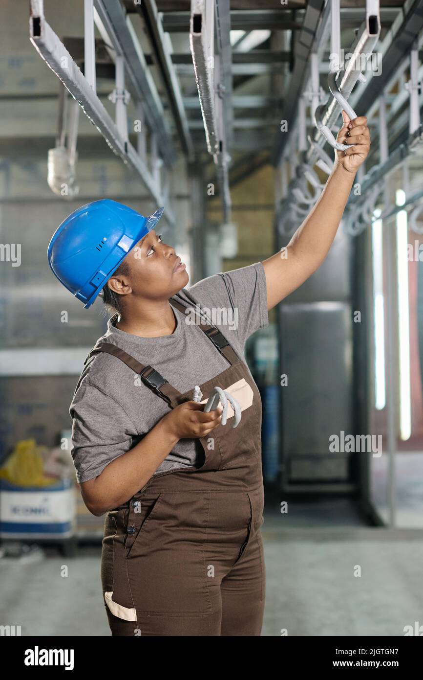 Factory female worker in hardhat preparing place for hanging finished ...