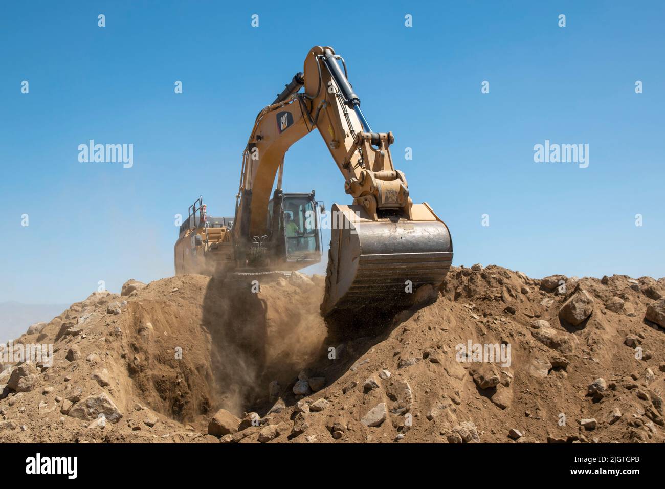 Heavy machinery works to break down rock for a highway project near ...