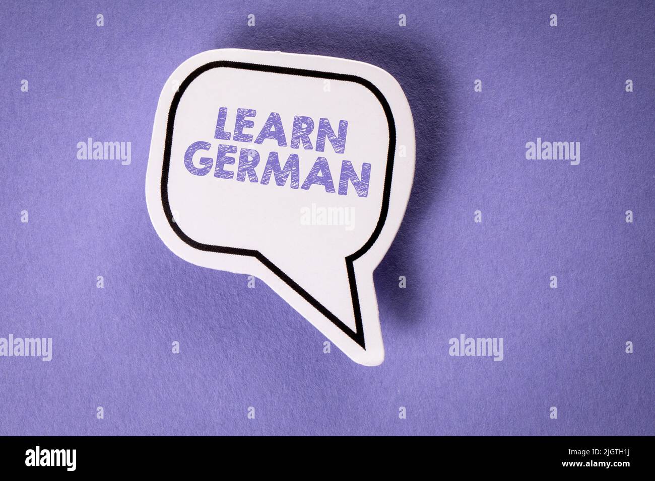 Learn German. White speech bubble on a purple background Stock Photo ...