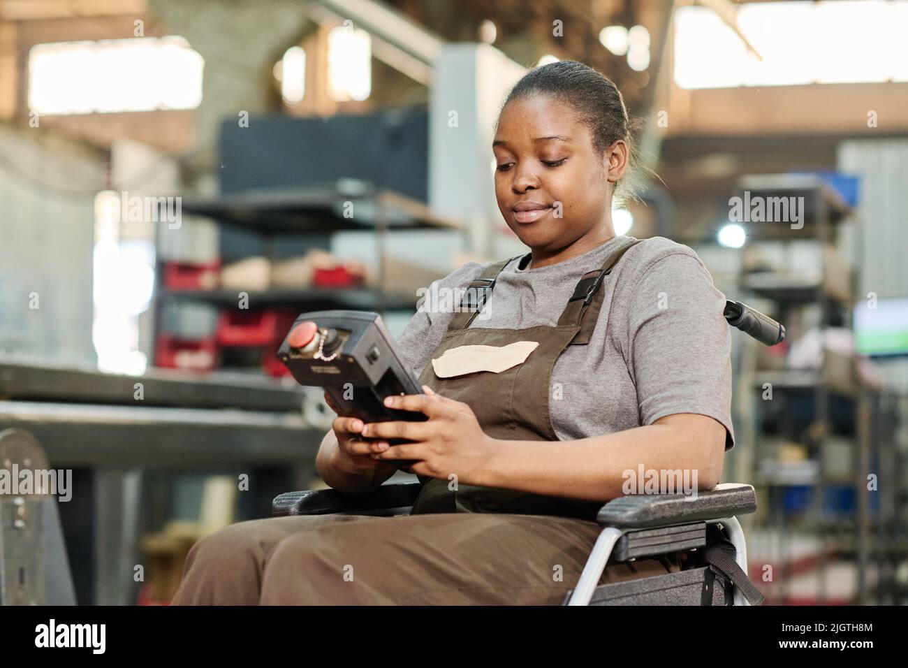 African female operator having a work at factory to control the work of ...
