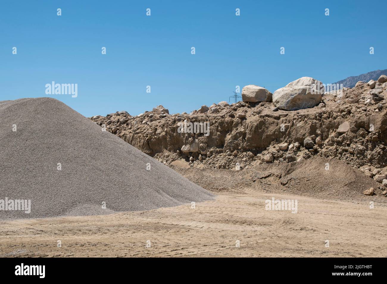Heavy machinery works to break down rock for a highway project near ...