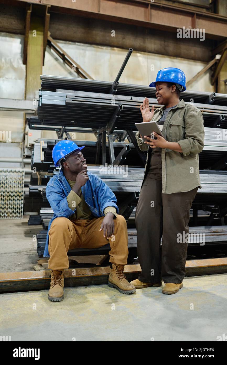 African female worker using tablet pc and discussing working moments ...