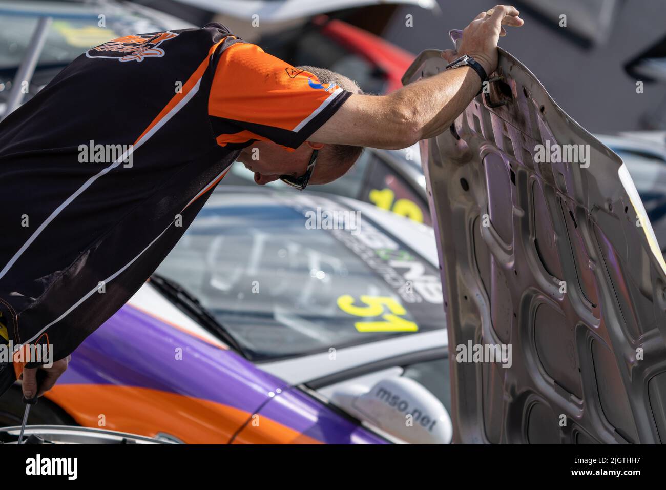 Engineer At Work Under Engine Bay In Paddock Stock Photo - Alamy