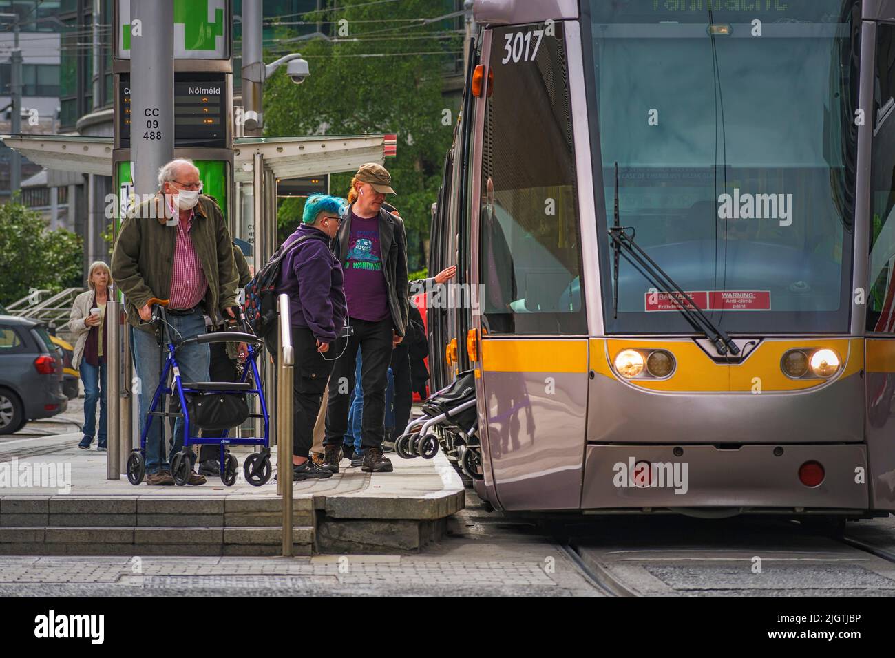 People are boarding the tram at the Busaras Luas stop. Dublin, Ireland ...