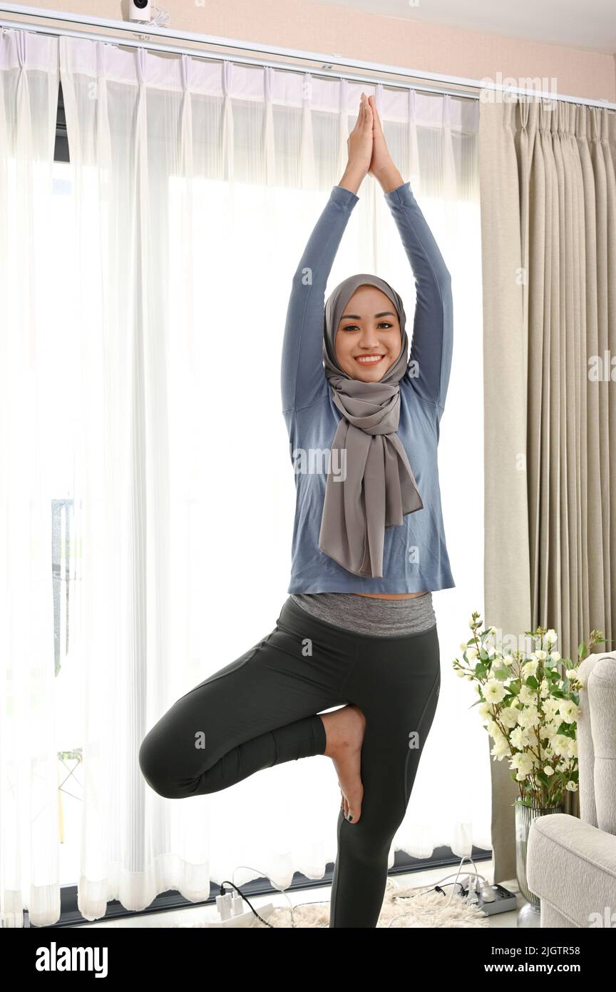 Active and healthy young Asian Muslim woman wearing hijab standing on ...