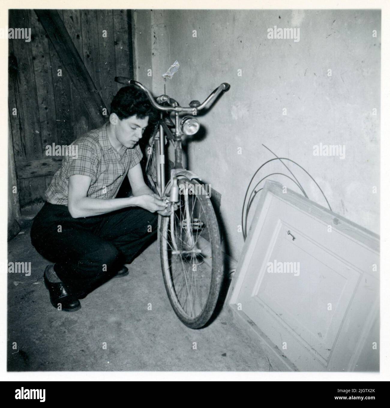 Sylve Wall sits squatting and fixing a bike Stock Photo - Alamy