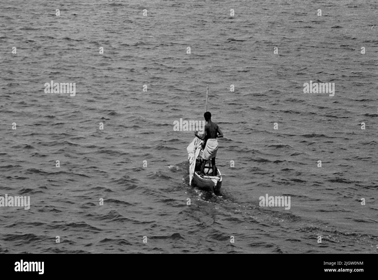 The Photo Taken About 1961 08 22 A Man Stands And Works With A Sail In A Small Sailboat He