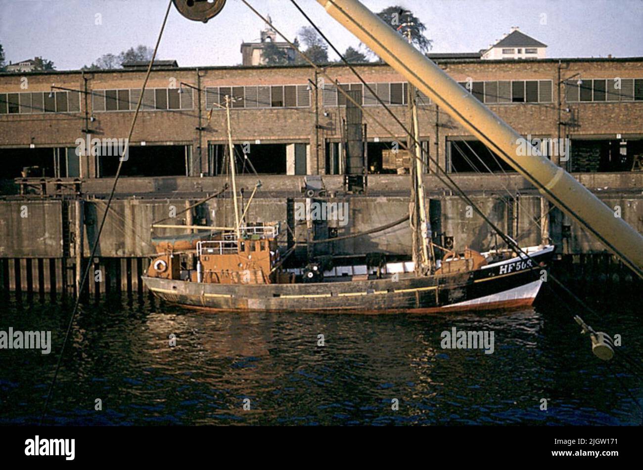 A Boat Is Located In A Harbor Along A Quay On The Quay Lies A Storage Room And There Is A