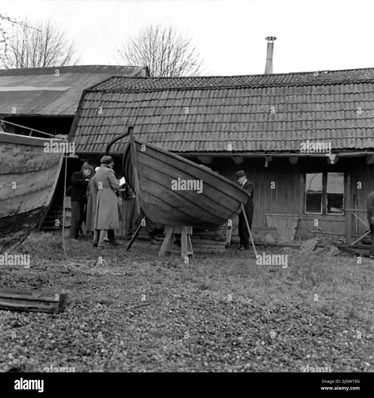 A boat is set up for an exhibition. At the boat, some women and men are ...