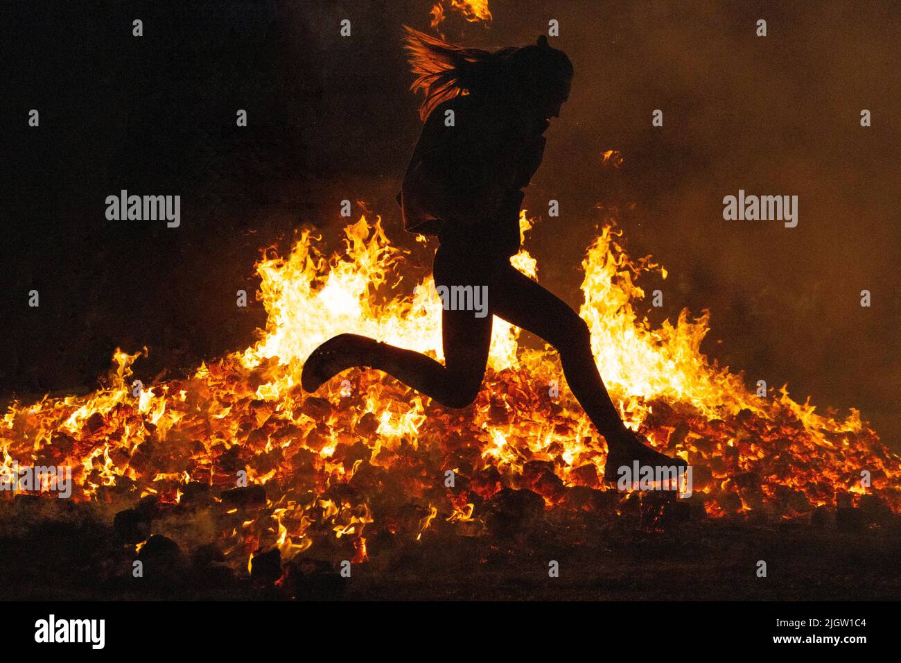 Summer solstice celebration jumping into the fire. Burning flames ...