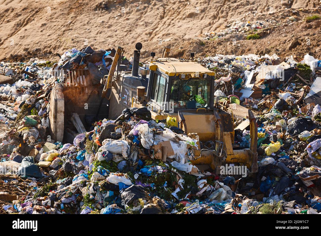 Heavy machinery shredding garbage in an open air landfill. Waste Stock ...