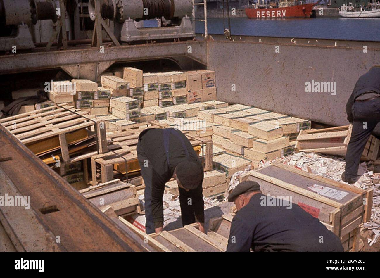 Three men unloading a ship located in a port Stock Photo - Alamy