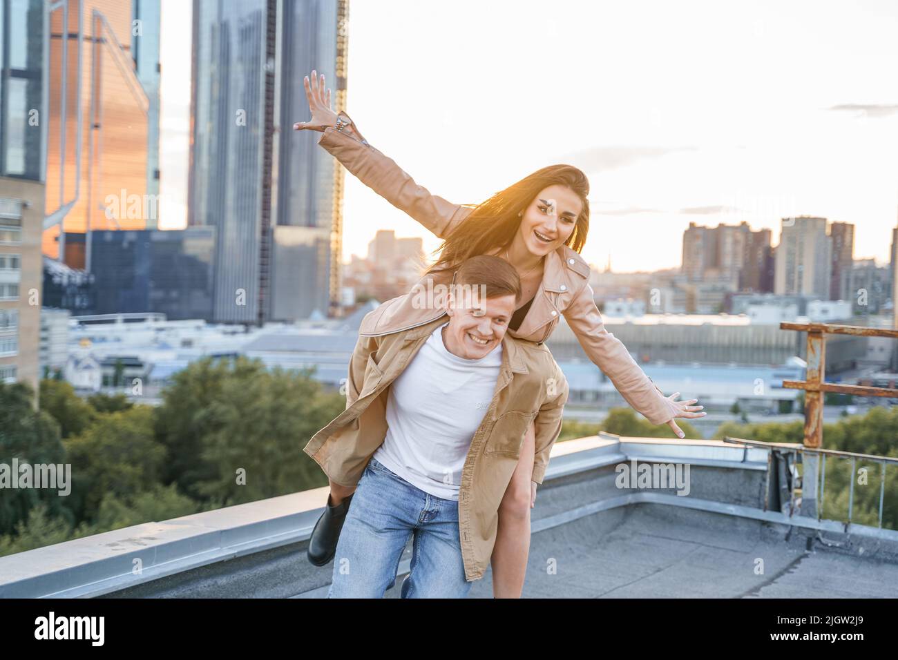 Happy young couple girl man guy on romantic love date on roof top with ...