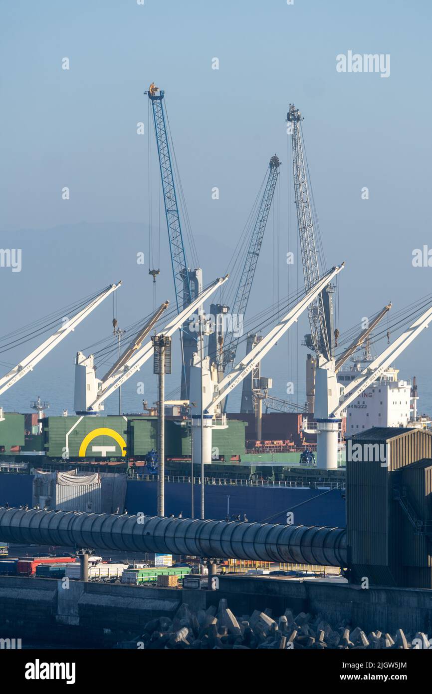 Cargo loading cranes on a bulk cargo freighter at the loading dock in ...