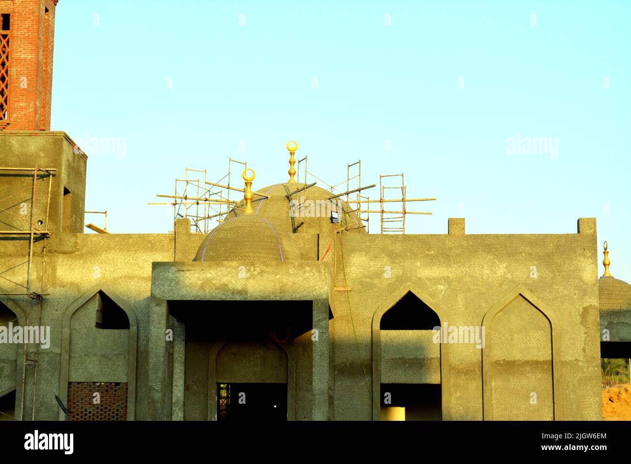 A new mosque under construction against the sunny blue sky with the ...