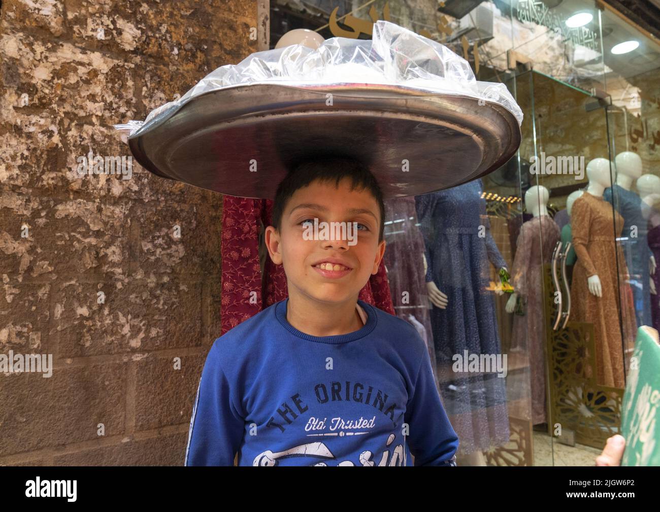 Young syrian boy carrying food on his head in the souk, North ...