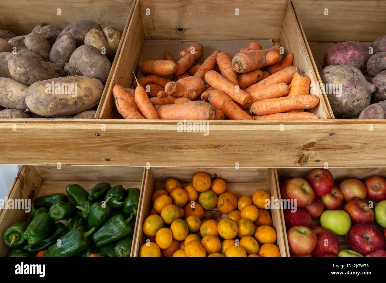 A variety of organic vegetables and fruits in wooden display stands ...