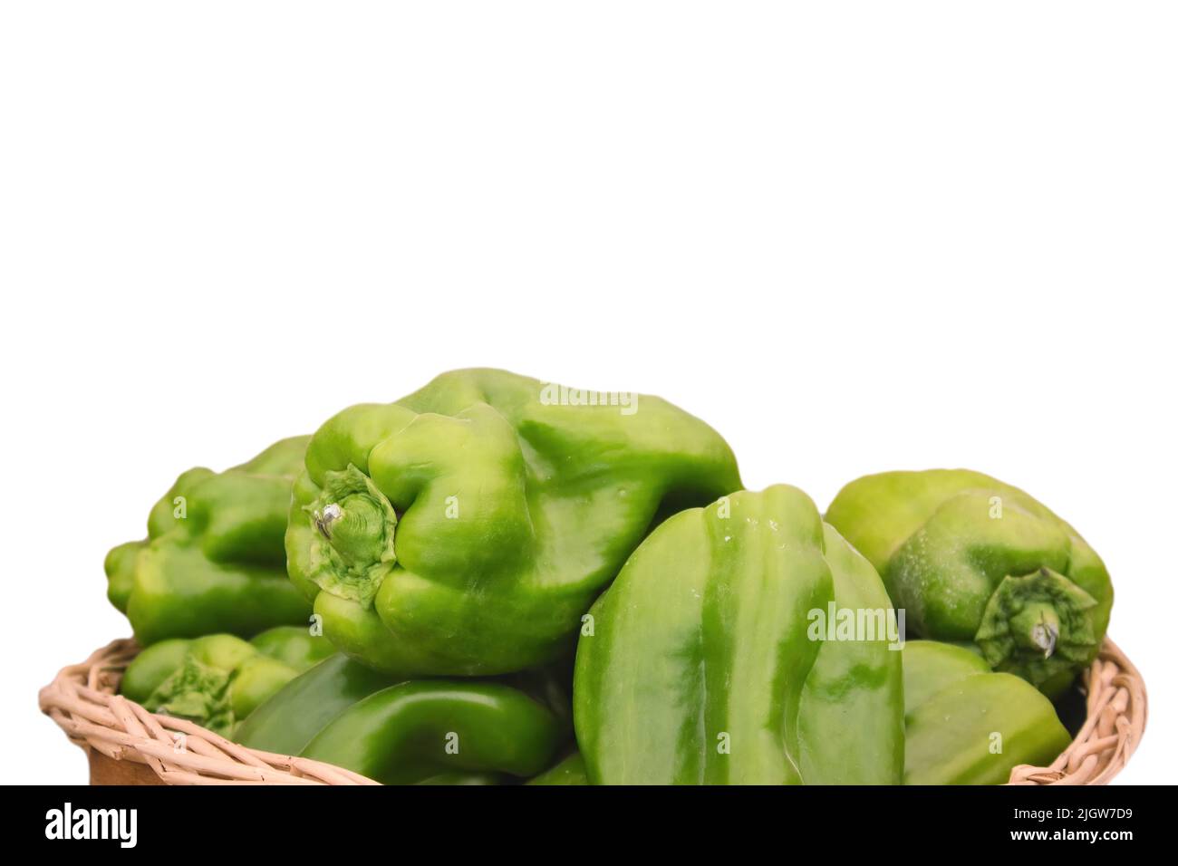 A basket of green bell peppers isolated against a pure white background ...