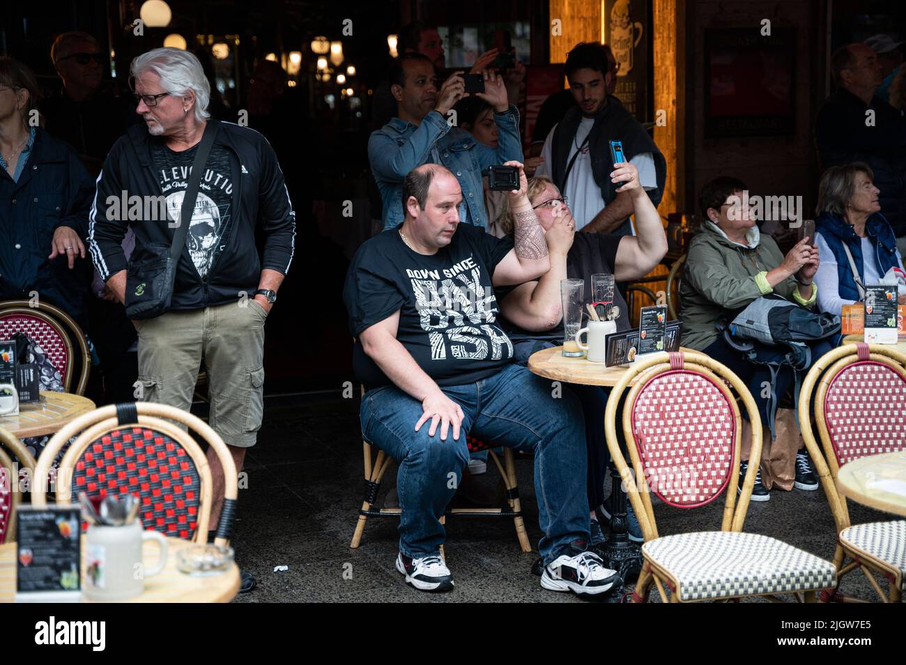 09.07.2022, Berlin, Germany, Europe - Guests at a street cafe watch the ...