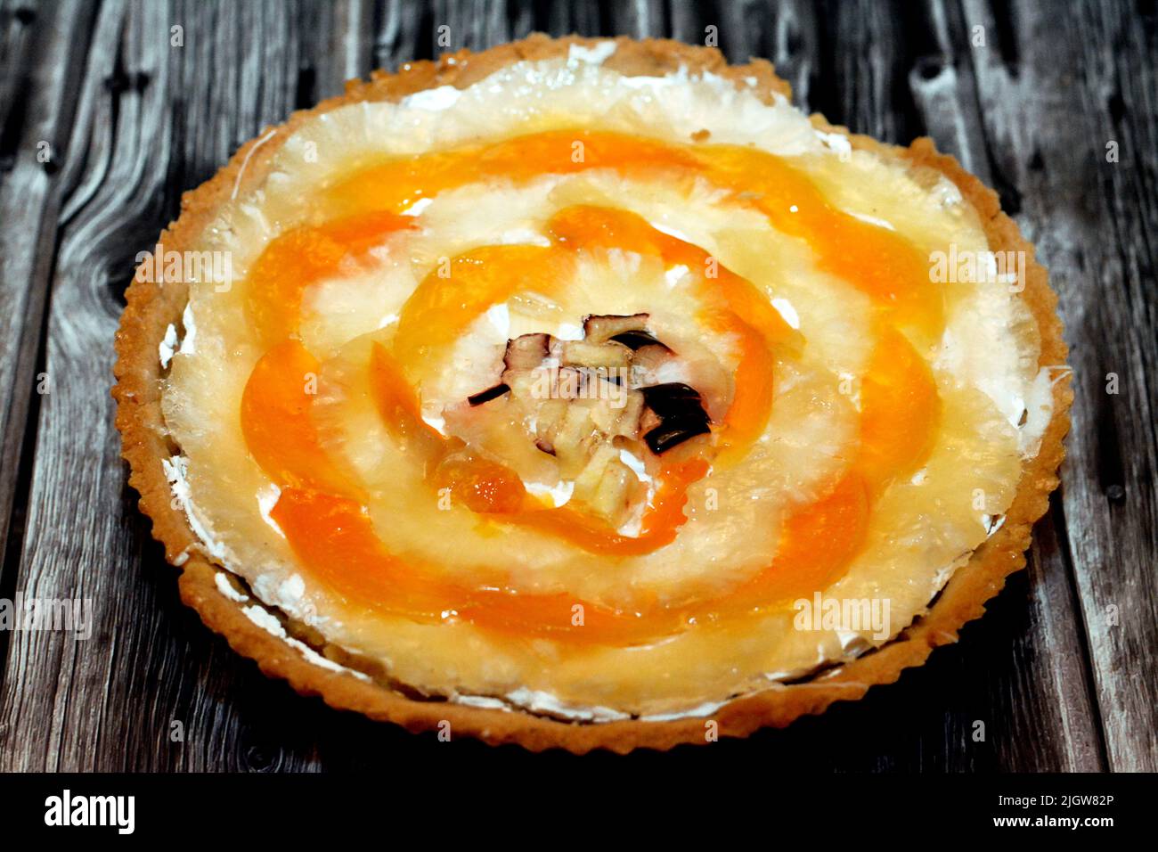 A tropical fruit tart cake with fresh pieces of apple, slices of fresh ...