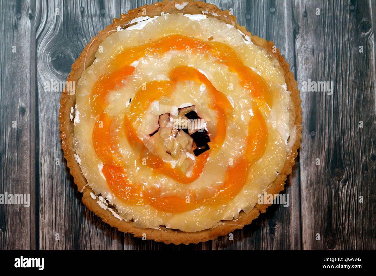 A tropical fruit tart cake with fresh pieces of apple, slices of fresh ...