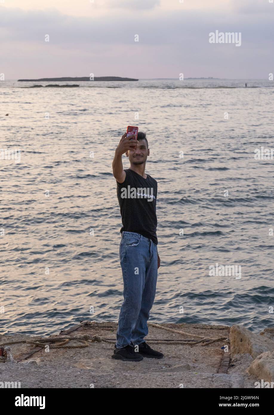 Young man taking selfie in front of the sea, North Governorate, Tripoli ...