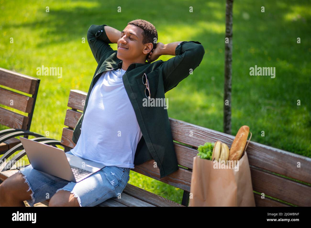 Guy resting sitting with closed eyes on bench Stock Photo - Alamy