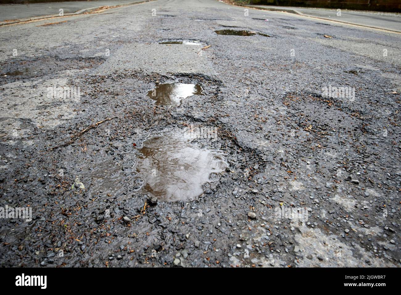 water filled potholes in the middle of a road in england uk Stock Photo ...
